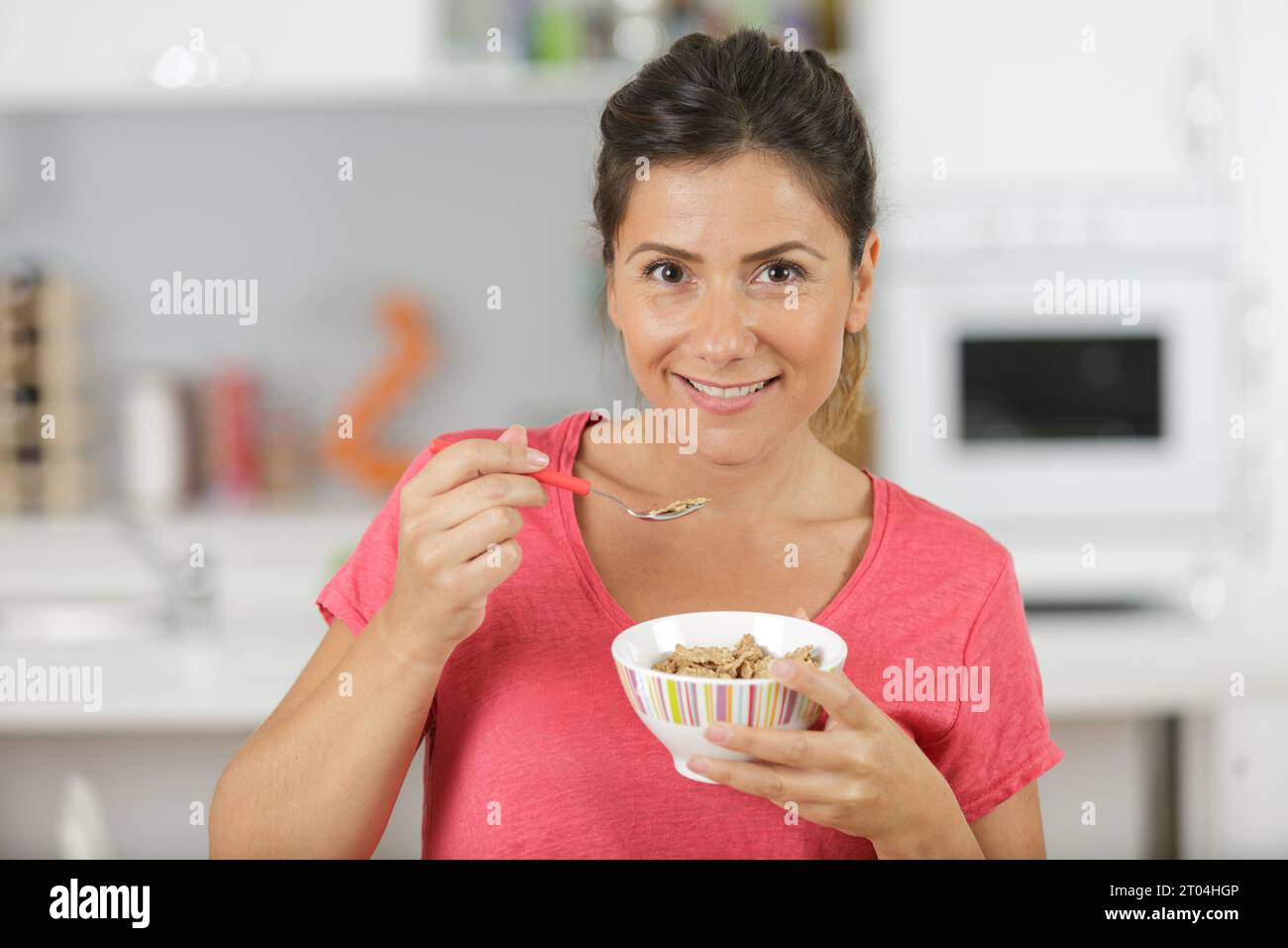 smiling healthy woman eating cornflakes Stock Photo - Alamy