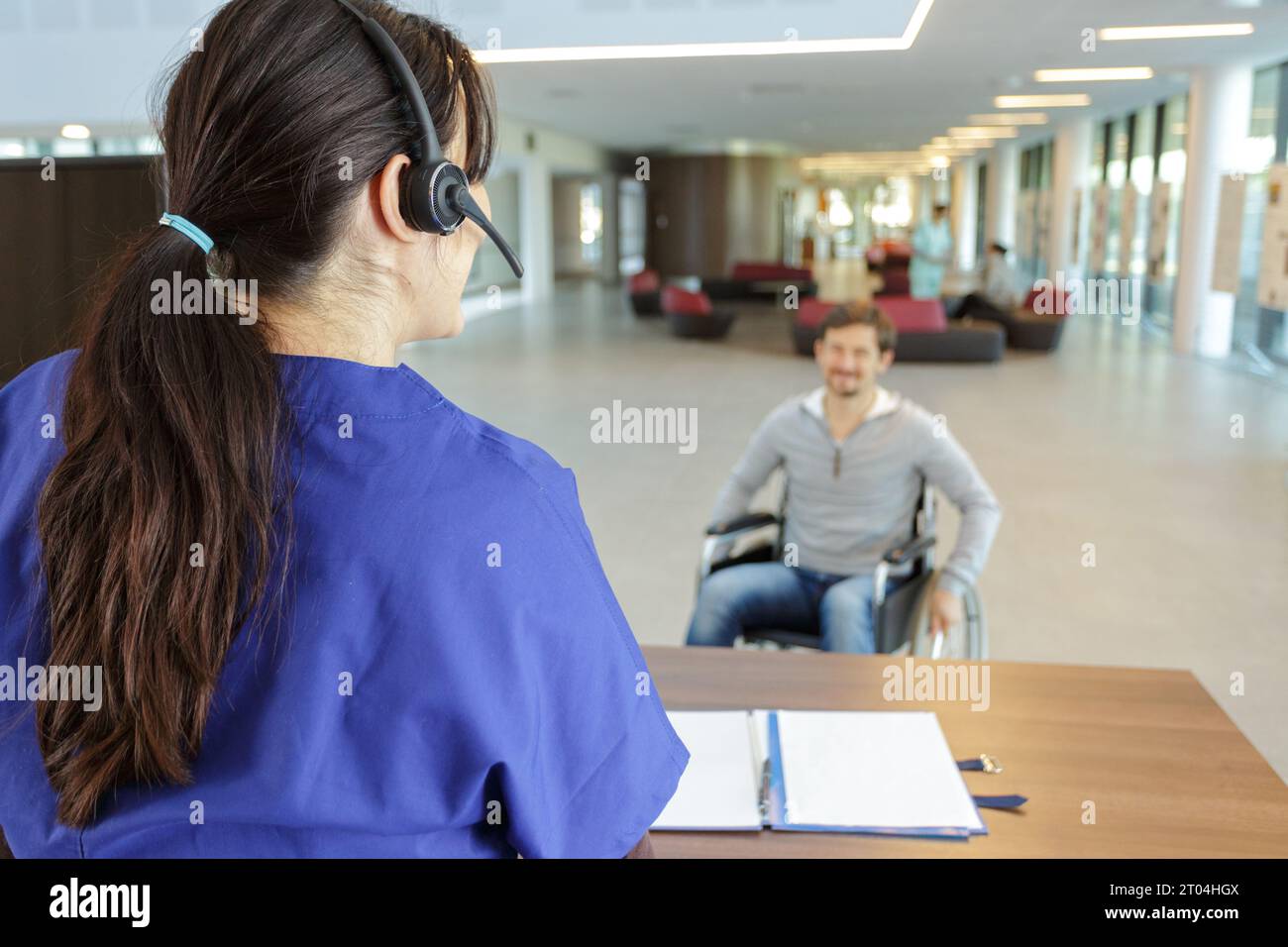 man in wheelchair in reception area Stock Photo - Alamy