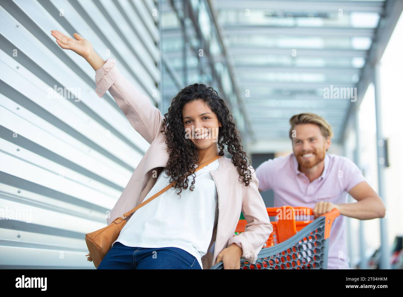 man pushing shopping cart with girlfriend leaning on the front Stock ...
