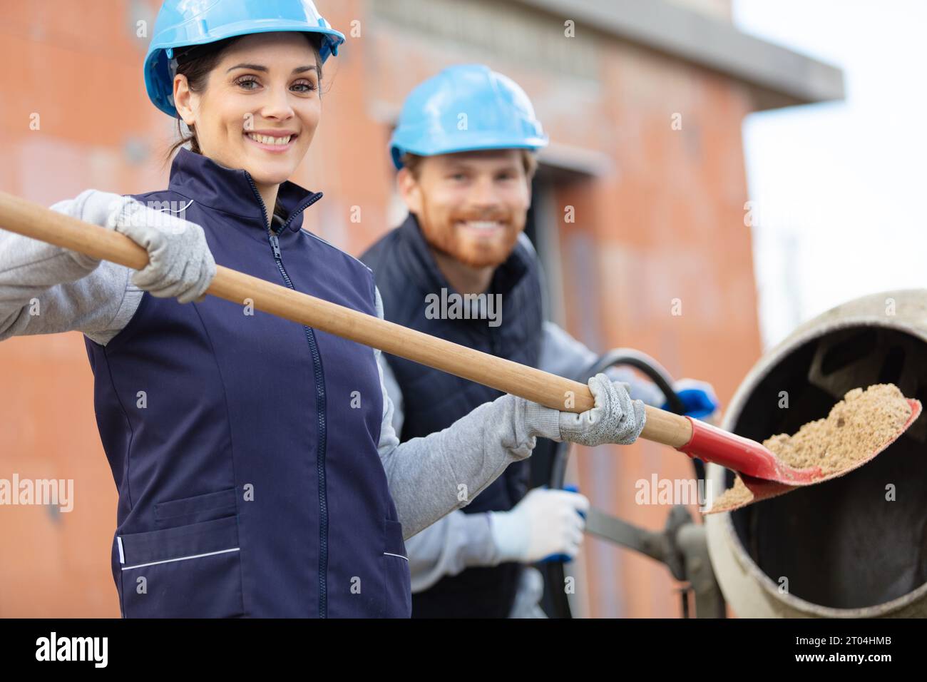 woman working hard on construction site holding shovel Stock Photo - Alamy