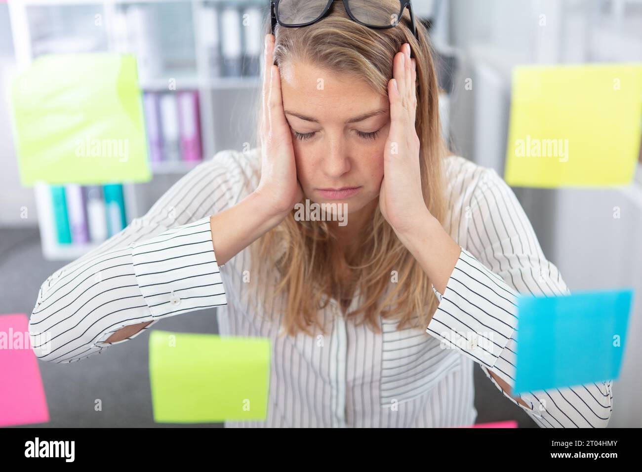 stressed woman looking at post it notes in office Stock Photo - Alamy