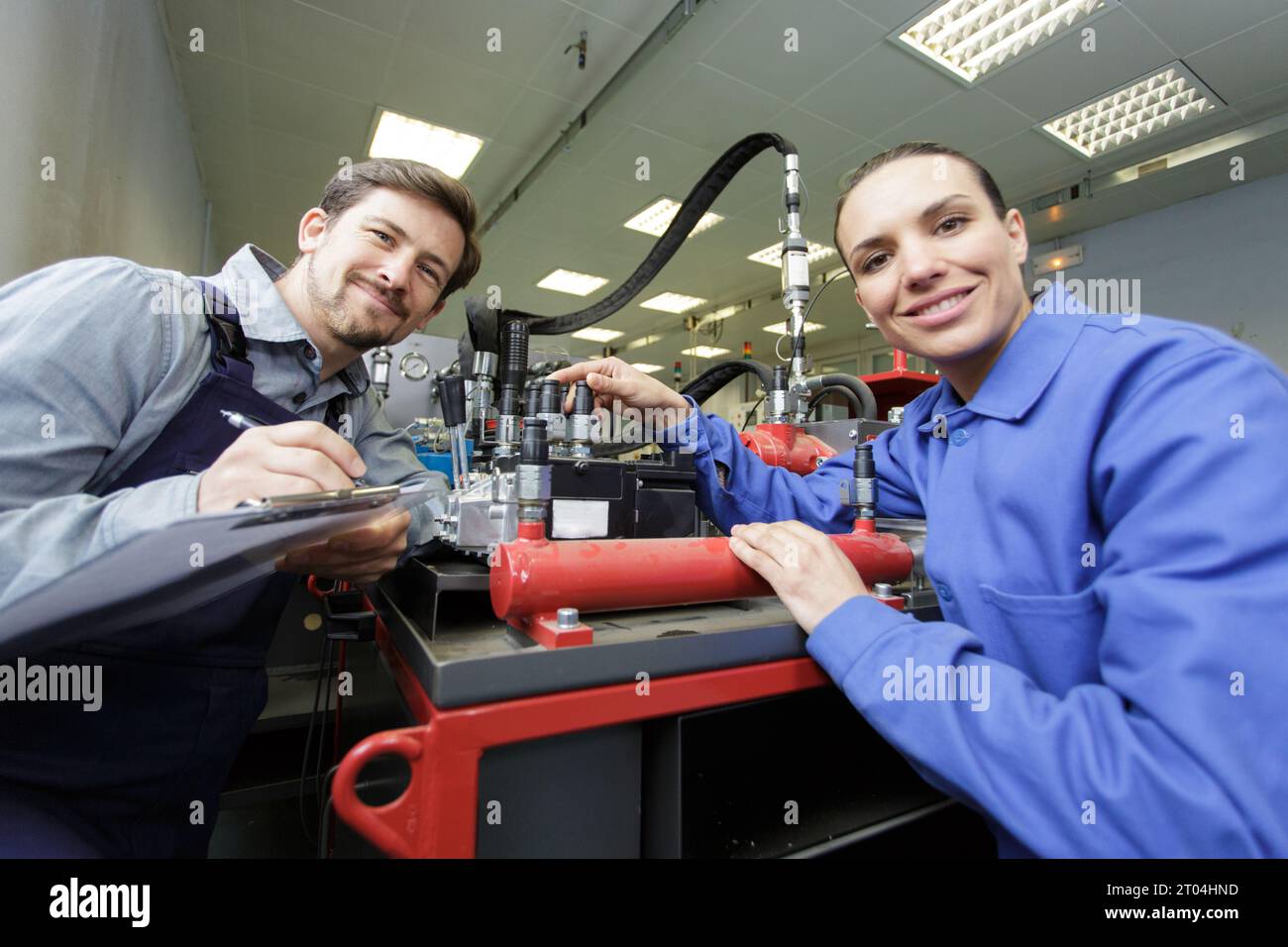 engineer teaching apprentice to use computerized lathe Stock Photo - Alamy