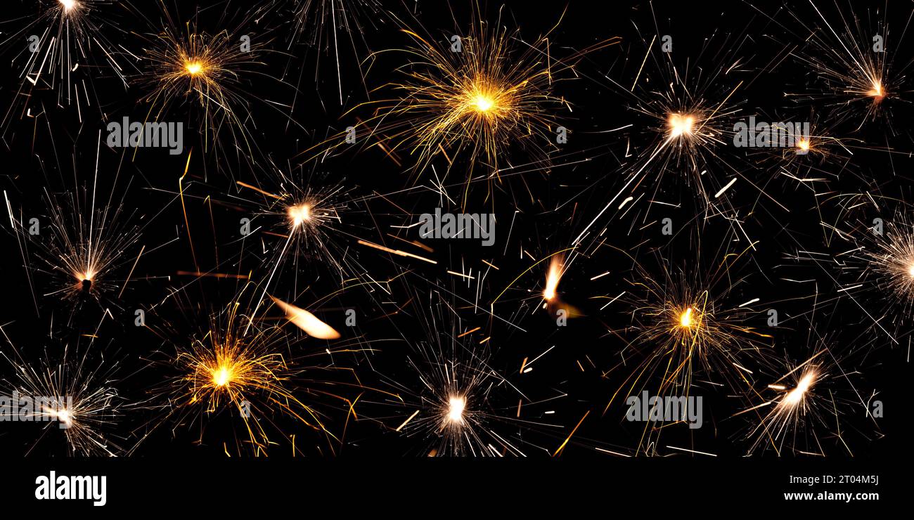 Banner with sparkling gold burning sparklers, flares, sparks on a black ...