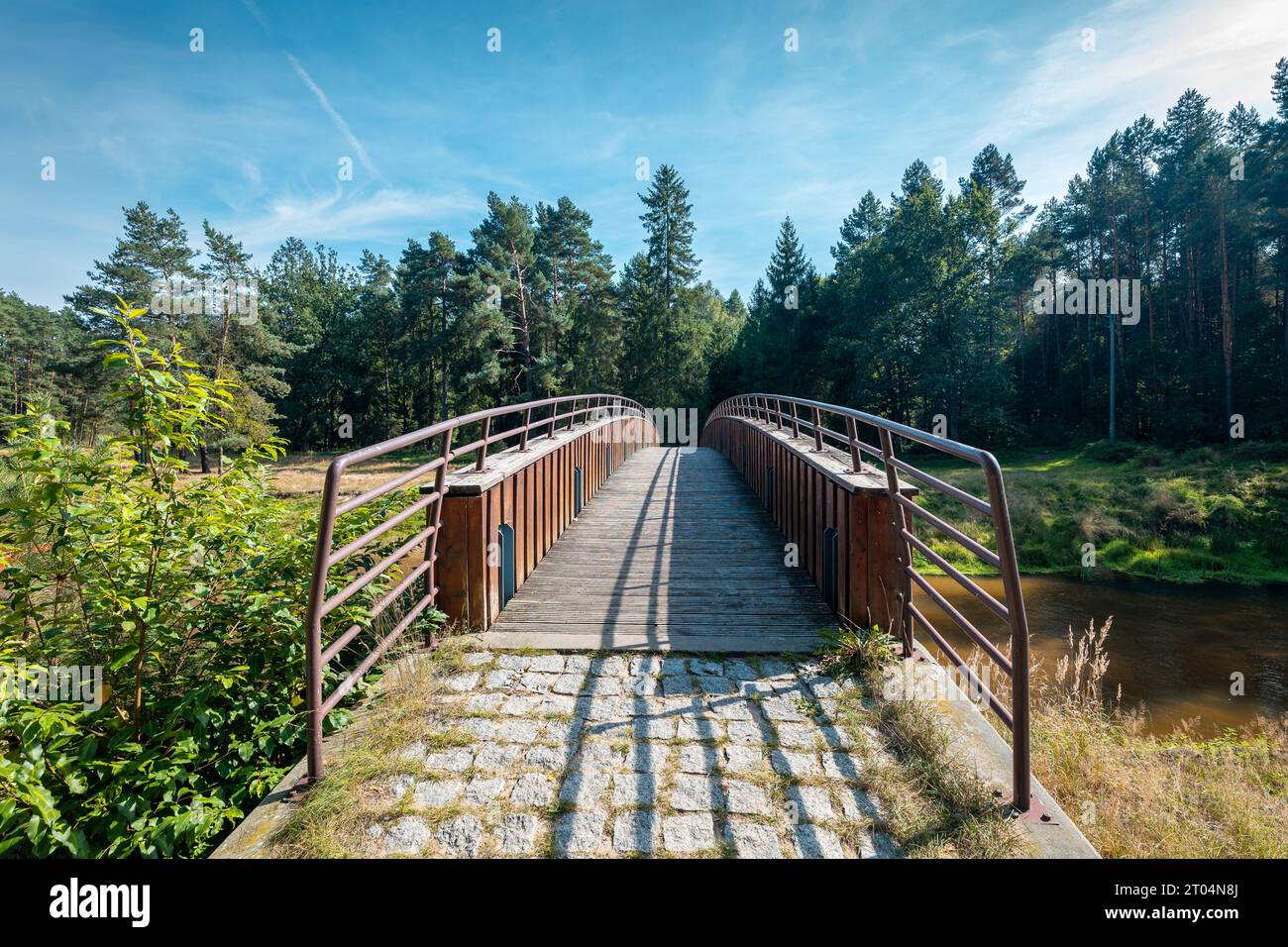 A footbridge with a wooden balustrade over the beautiful and ...