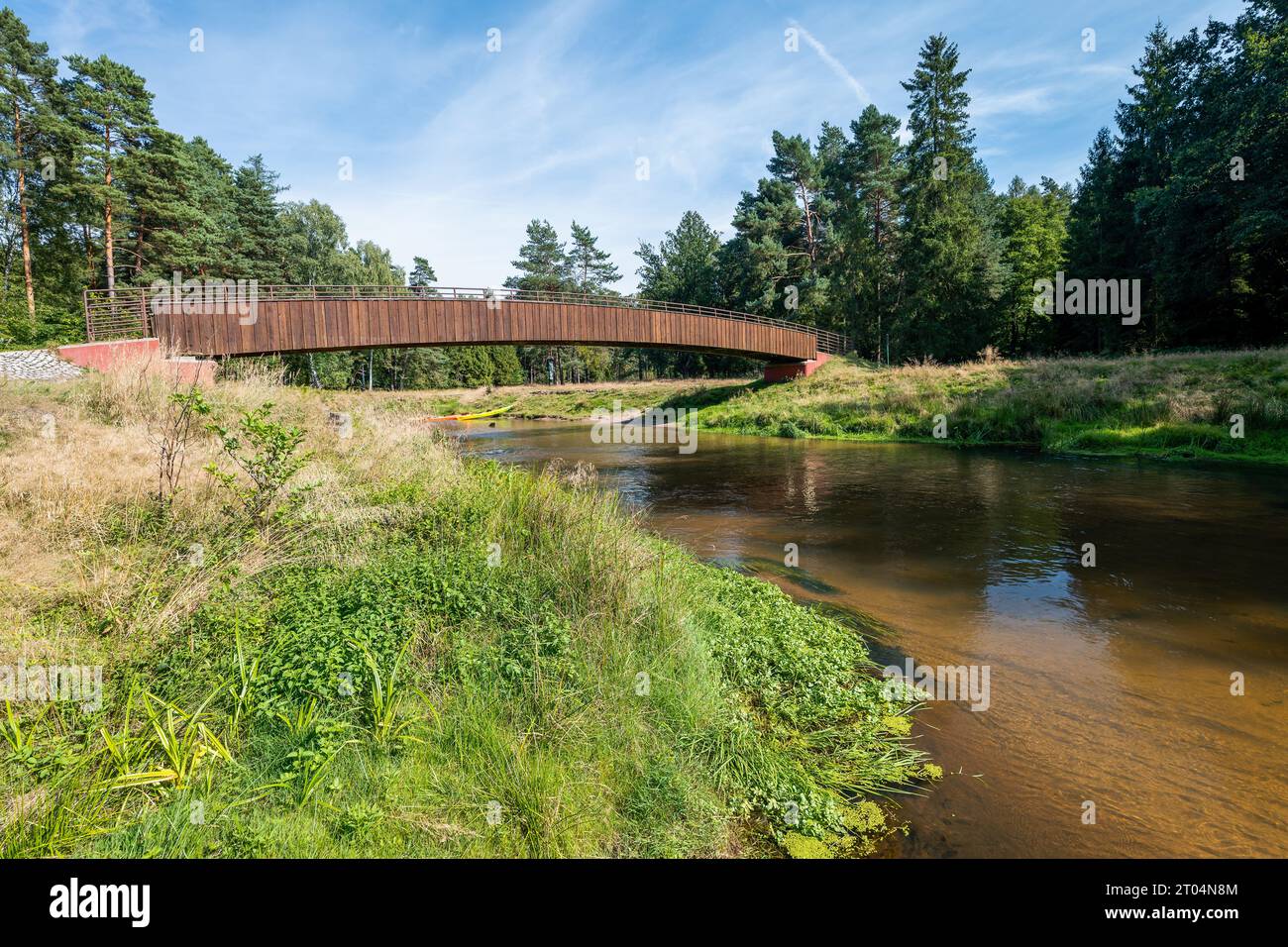 A footbridge with a wooden balustrade over the beautiful and ...