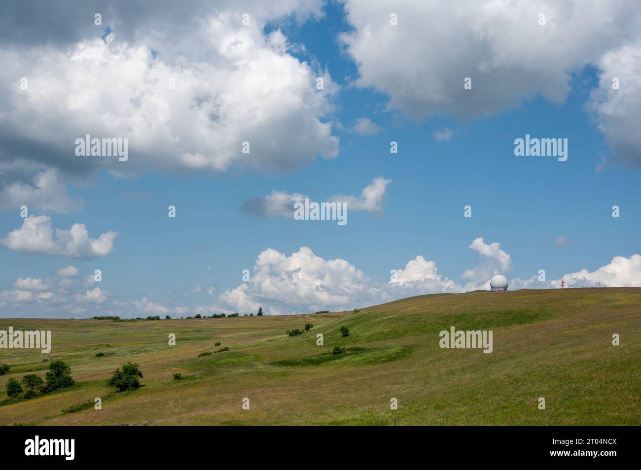 Radome (antenna dome) on the Wasserkuppe with a green meadow and blue ...