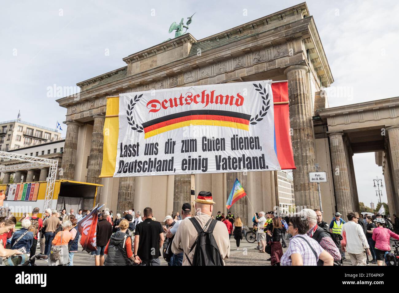 A demonstrator holds a banner that says, "Let us serve you for the good ...
