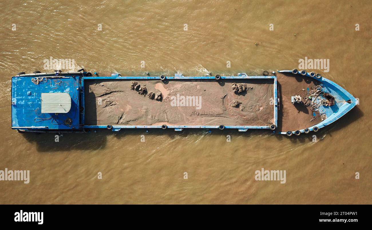 Aerial drone view, vietnamese cargo ship barge overloaded with sand ...