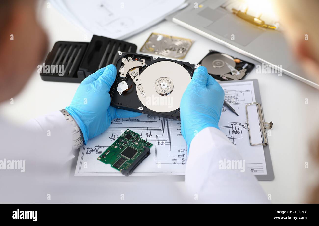 Technician repairs computer hard drive from motherboard Stock Photo - Alamy