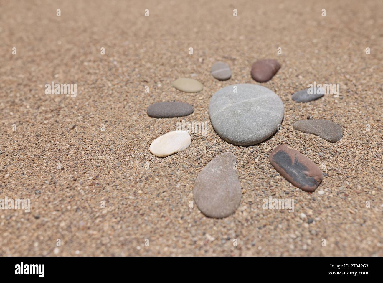 Figure of sun is made of pebble stones on sandy beach in summer Stock ...