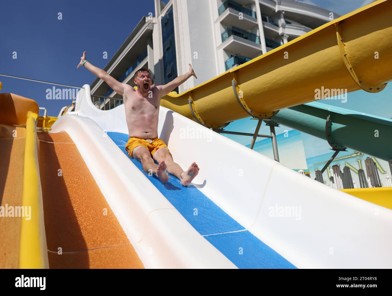 Emotional man screams in horror going down water slide Stock Photo - Alamy