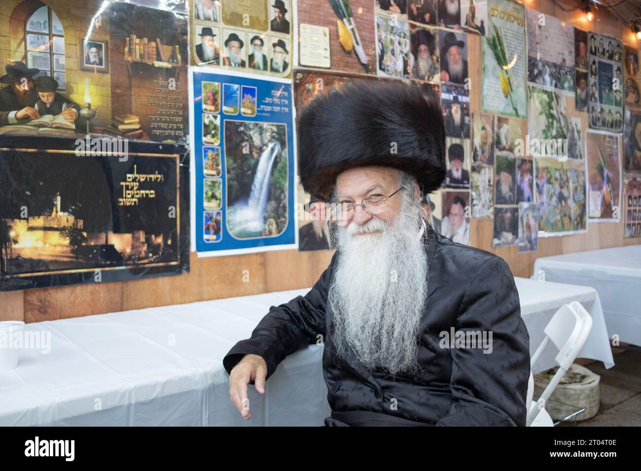 A Jewish man wearing a shtreimel fur hat poses for a photo in a Sukkah ...