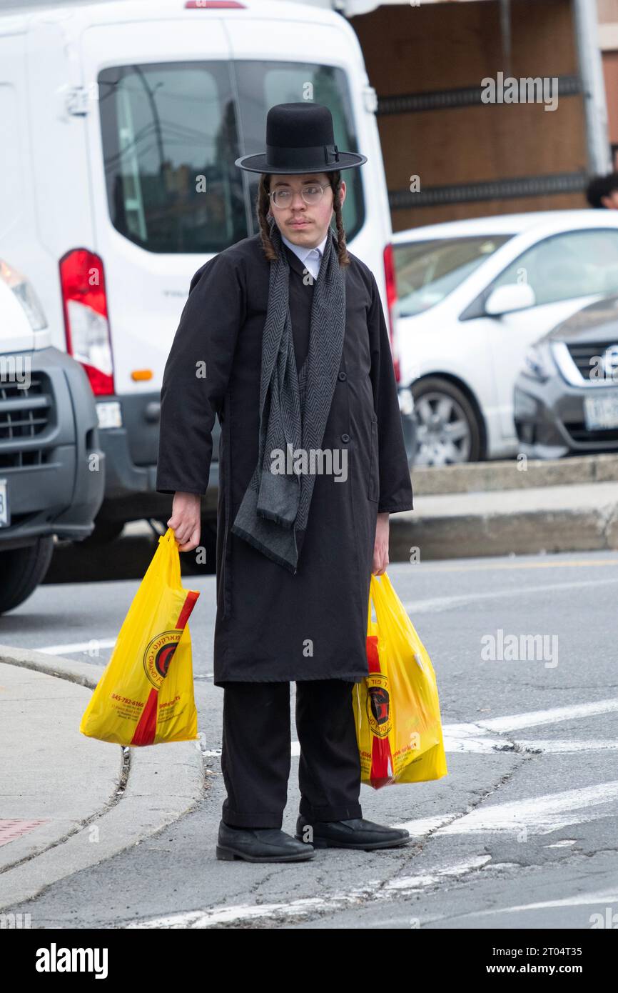 A young orthodox jewish man wauts to cross the street after shopping ...