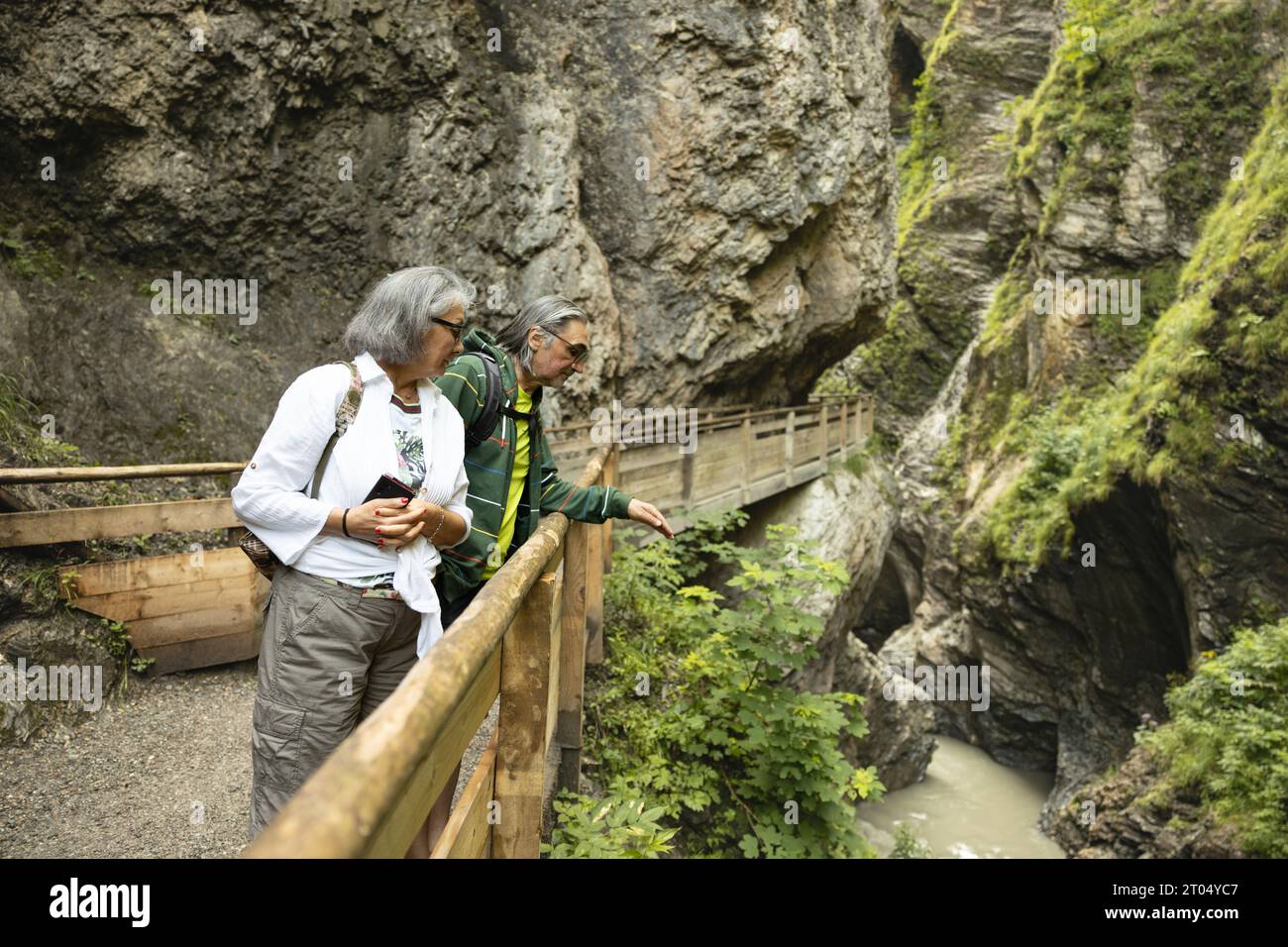 An adult couple, a man and a woman, walk through the Liechtensteinklamm ...