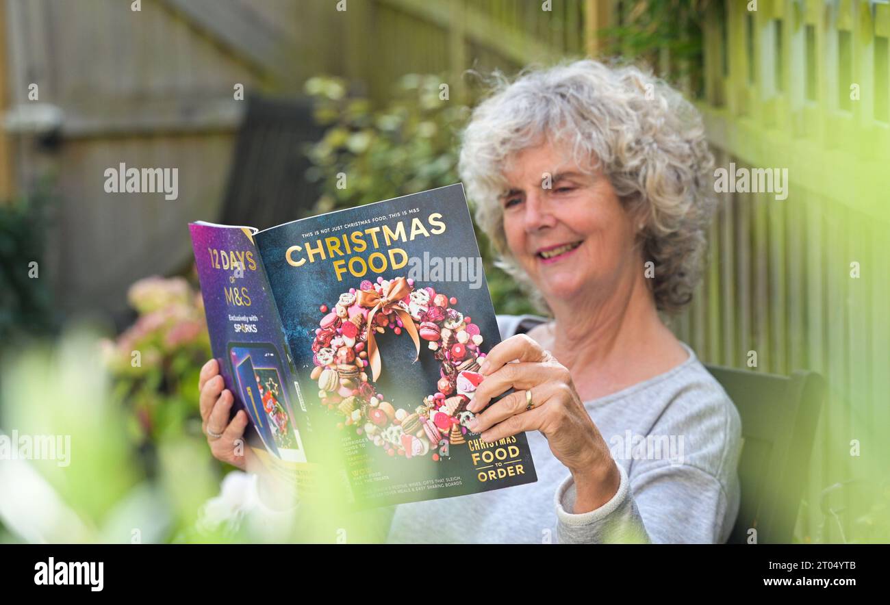 Woman reading the Marks & Spencer ( M&S) Christmas food ordering ...