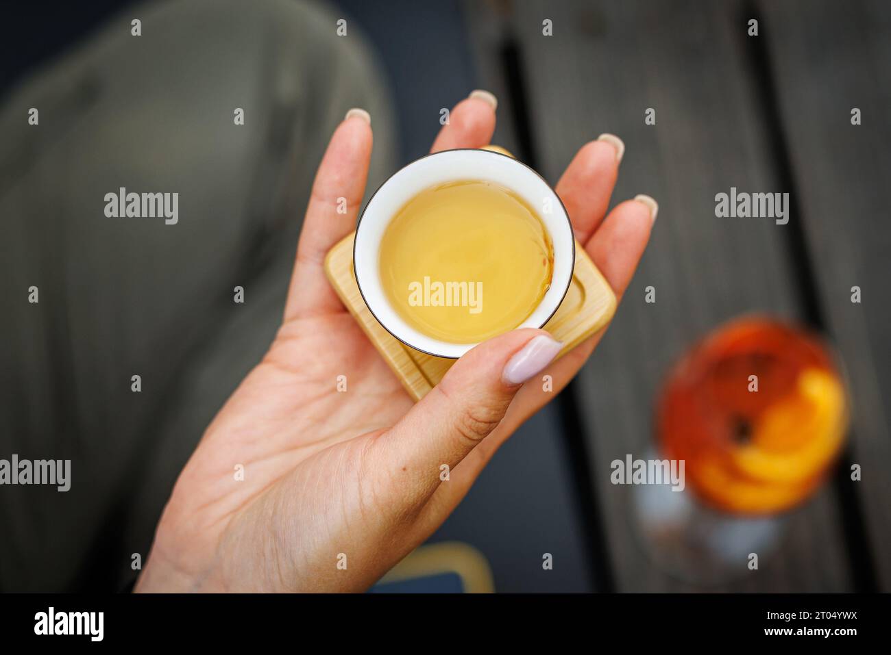 Tiny Chinese teacup in woman's hands during a tea ceremony Stock Photo ...