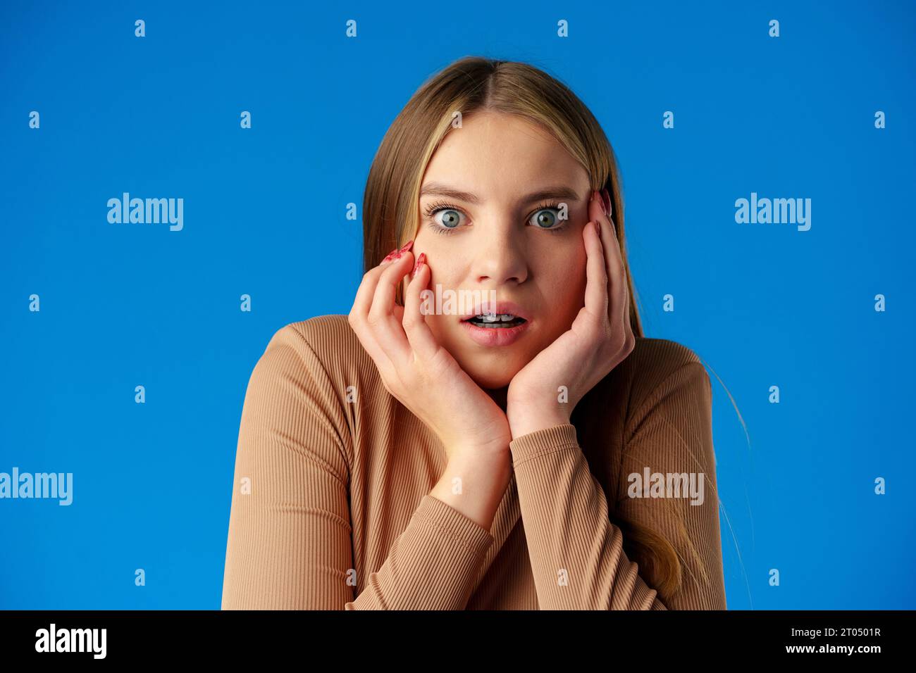 Portrait of worried anxious girl over blue background in studio Stock ...