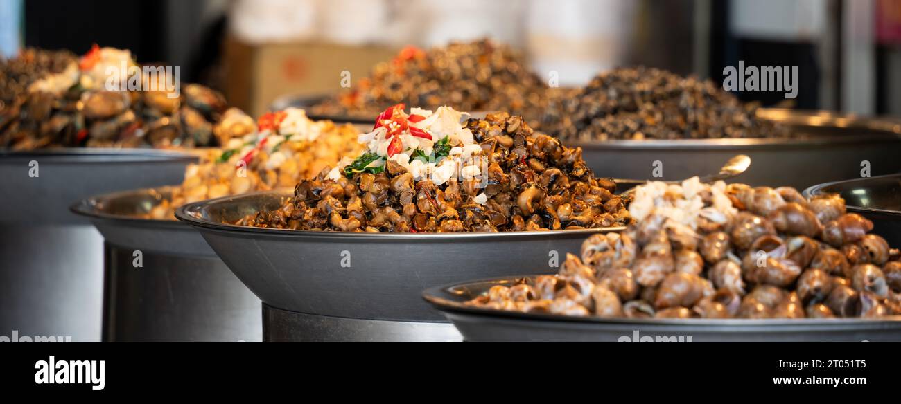 Stir-fried spicy flavored snail meat, delicious traditional street food ...