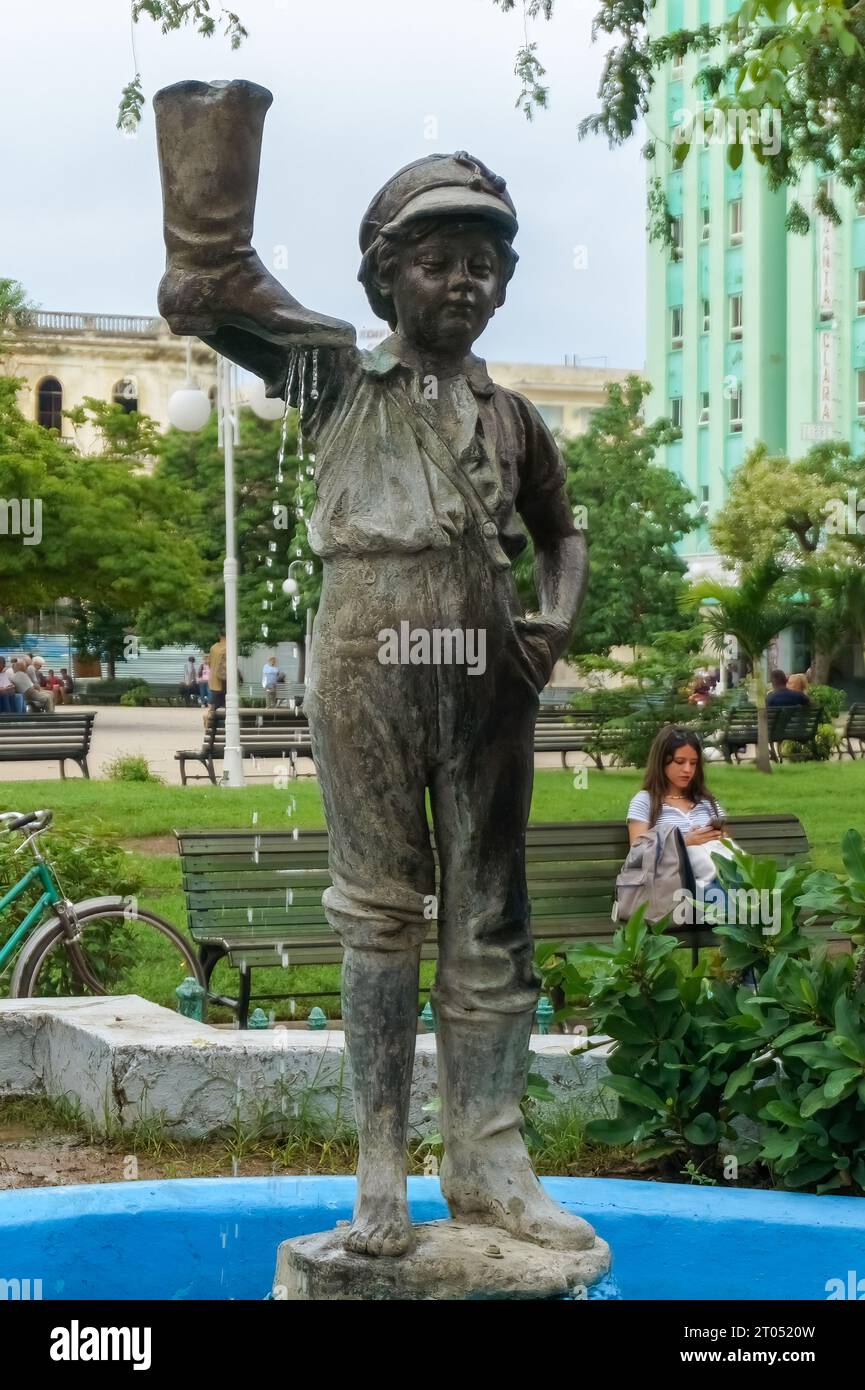 Metal statue in the fountain known as Child With Boot. Water is flowing ...