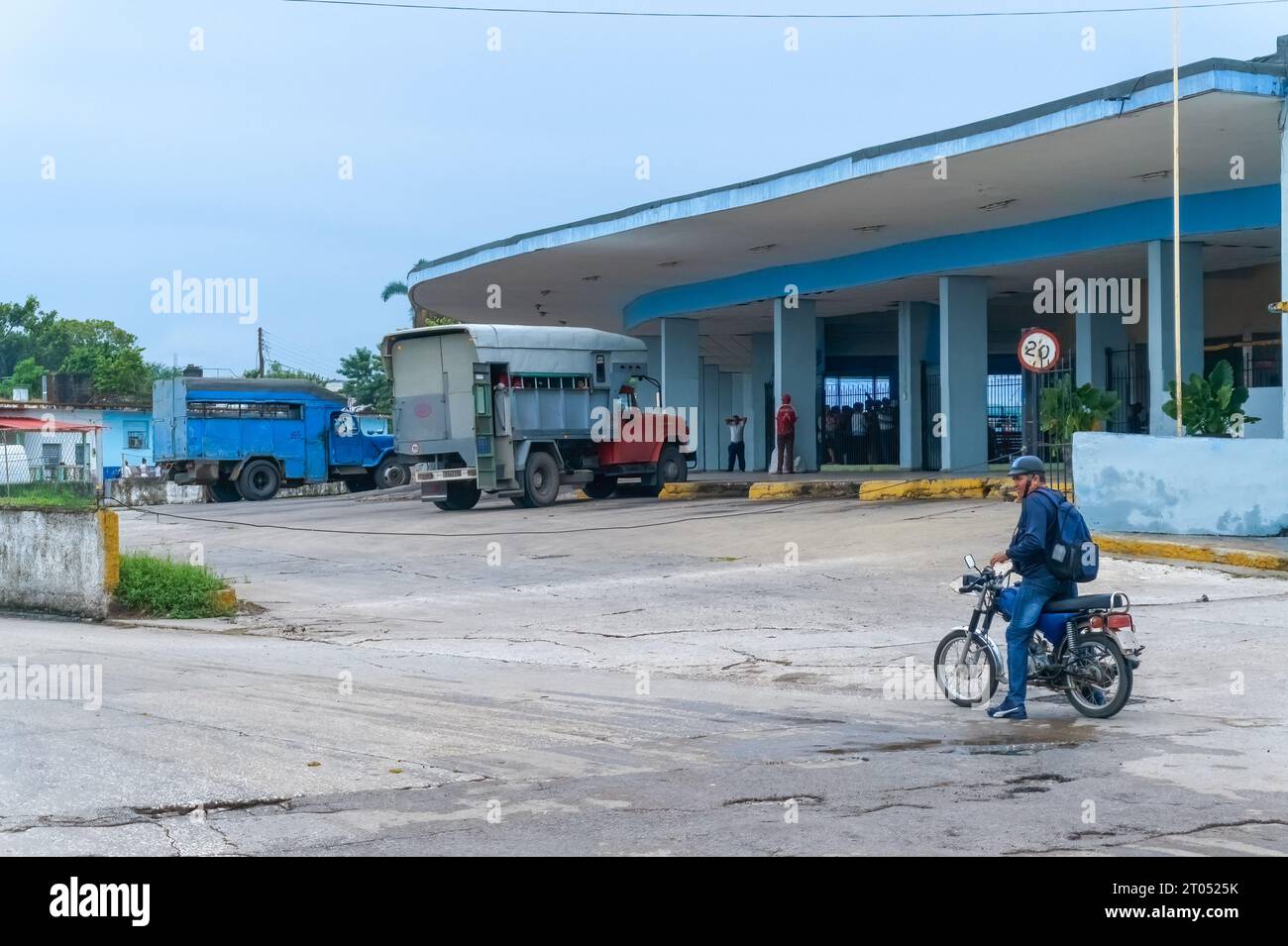 A man rides a motorcycle by the Intermunicipal BusTerminal. Instead of ...