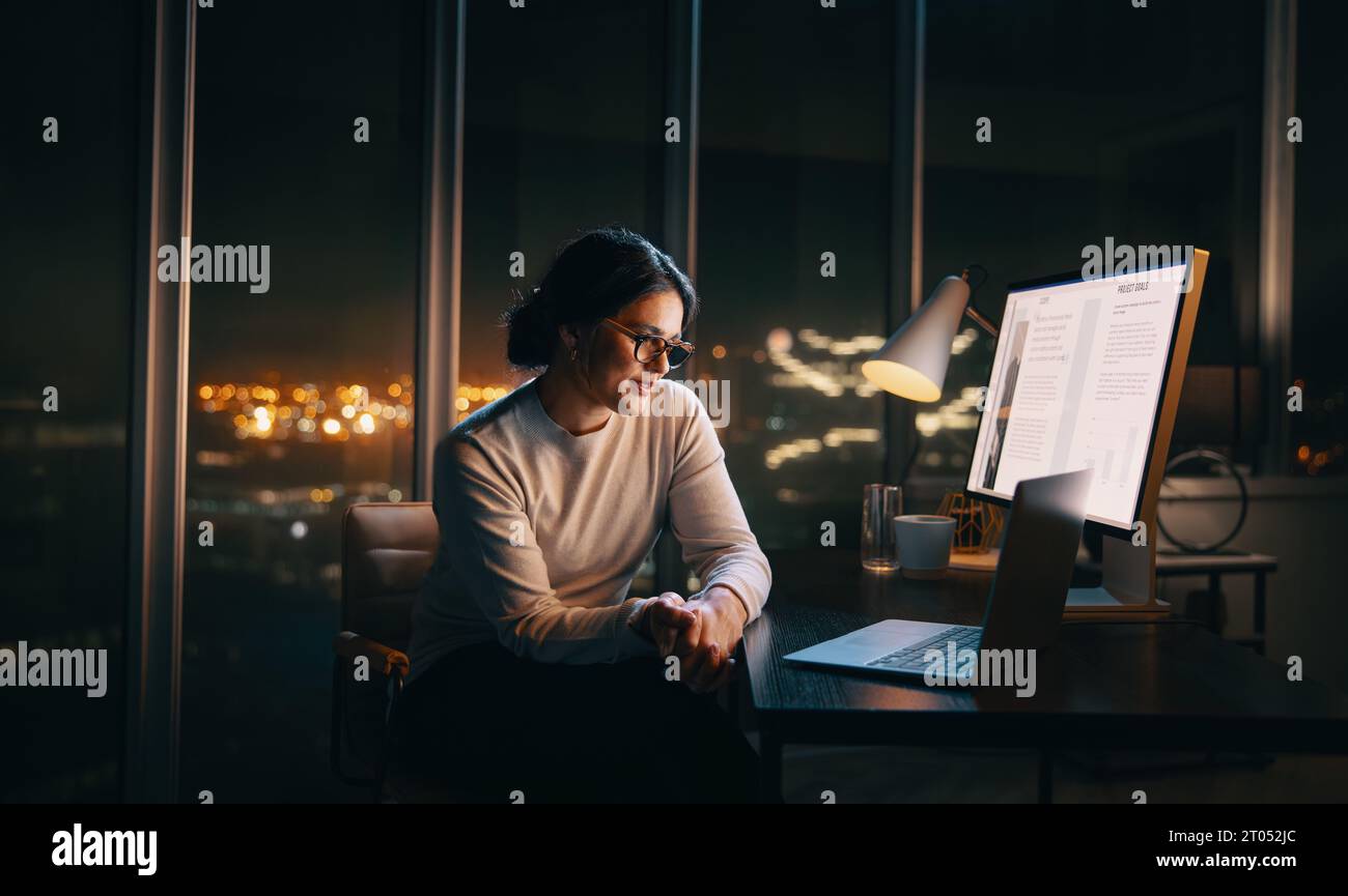 business woman engaging in a late-night virtual meeting on her laptop ...