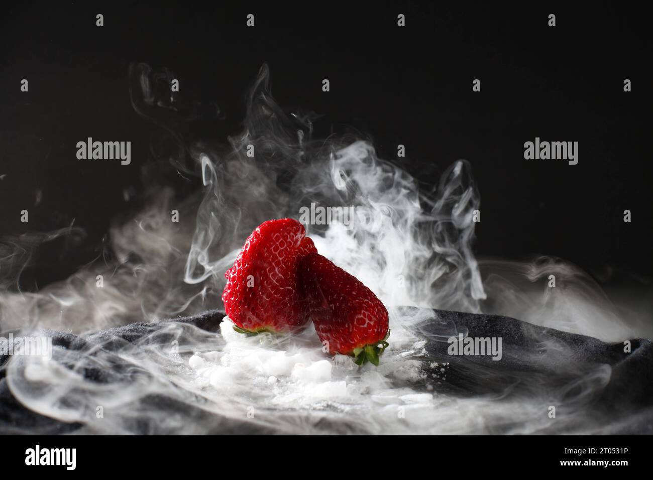 Fresh red strawberries with dry ice smoke and black background Stock ...
