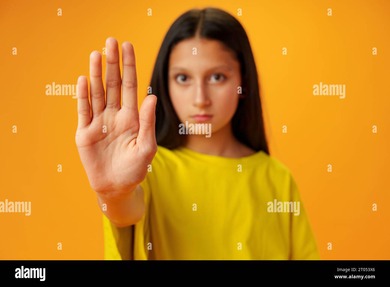 Teen girl extend hand in block gesture against yellow background Stock ...