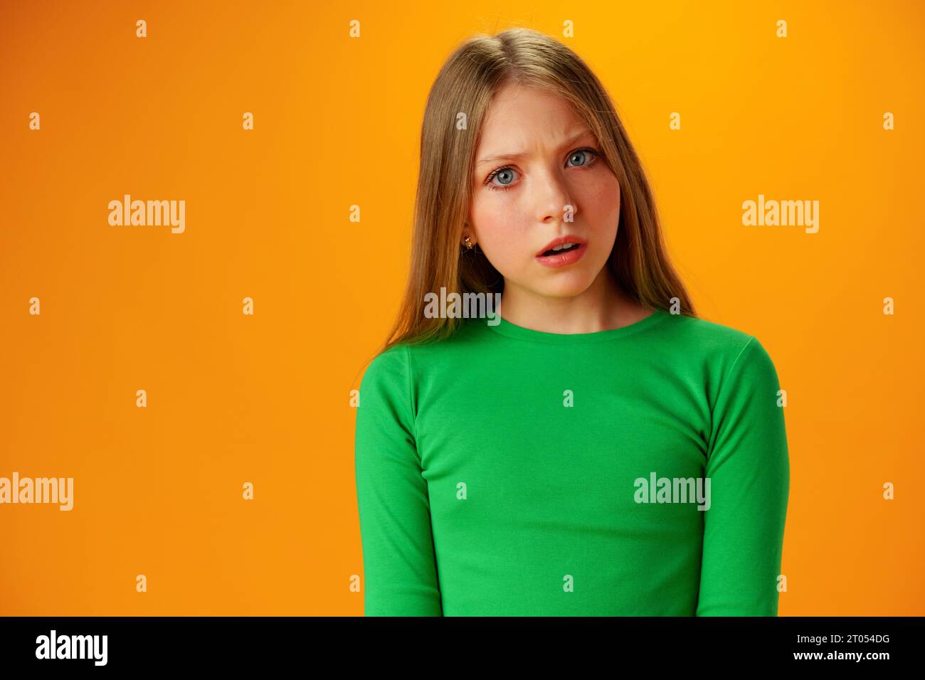 Upset disturbed teen girl on yellow background in studio Stock Photo ...