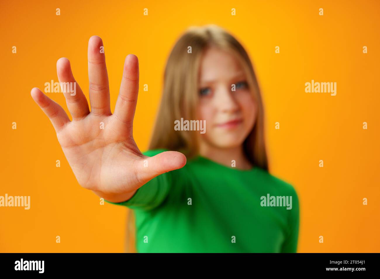 Teen girl extend hand in block gesture against yellow background Stock ...
