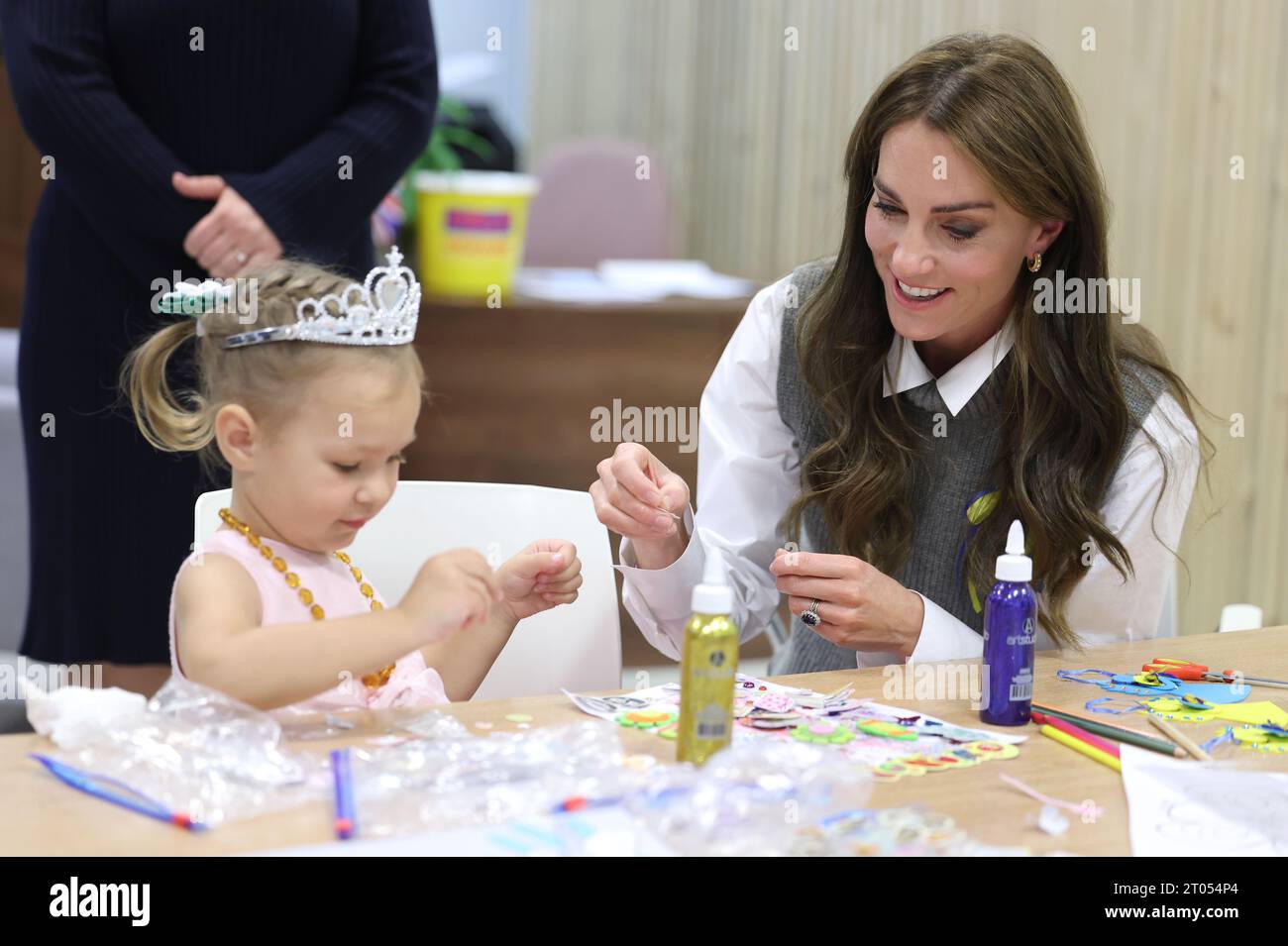 The Princess of Wales smiles as she helps a young girl at an arts and ...