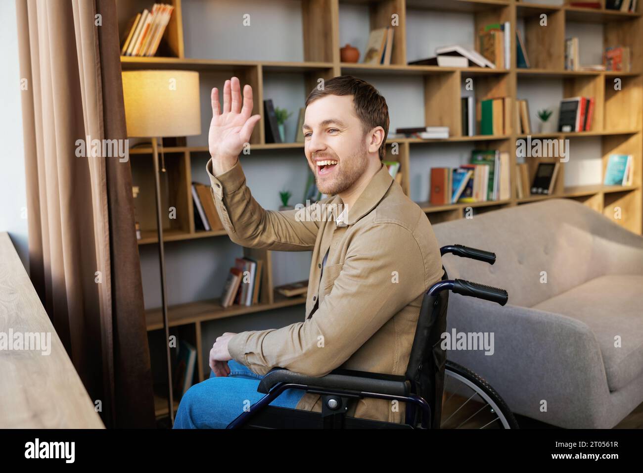 Man on wheelchair in room looking through window and smiling. Side view ...