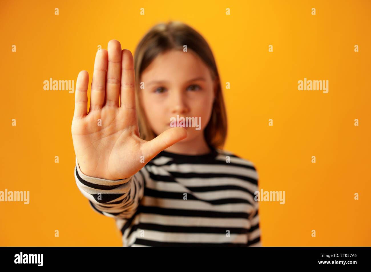 Teen girl extend hand in block gesture against yellow background Stock ...