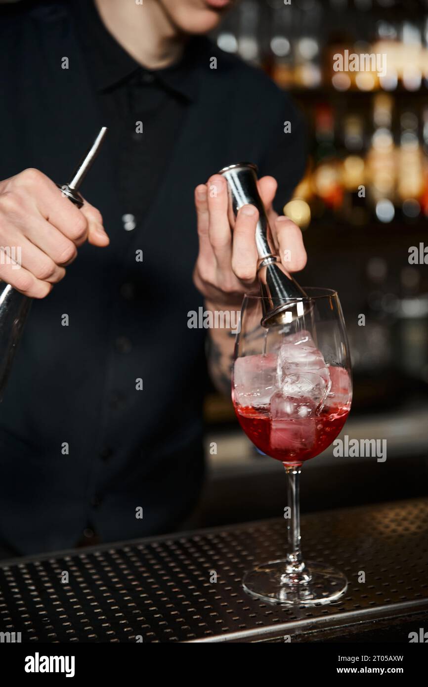 cocktail artistry, cropped view of bartender adding ice cubes in fruit ...