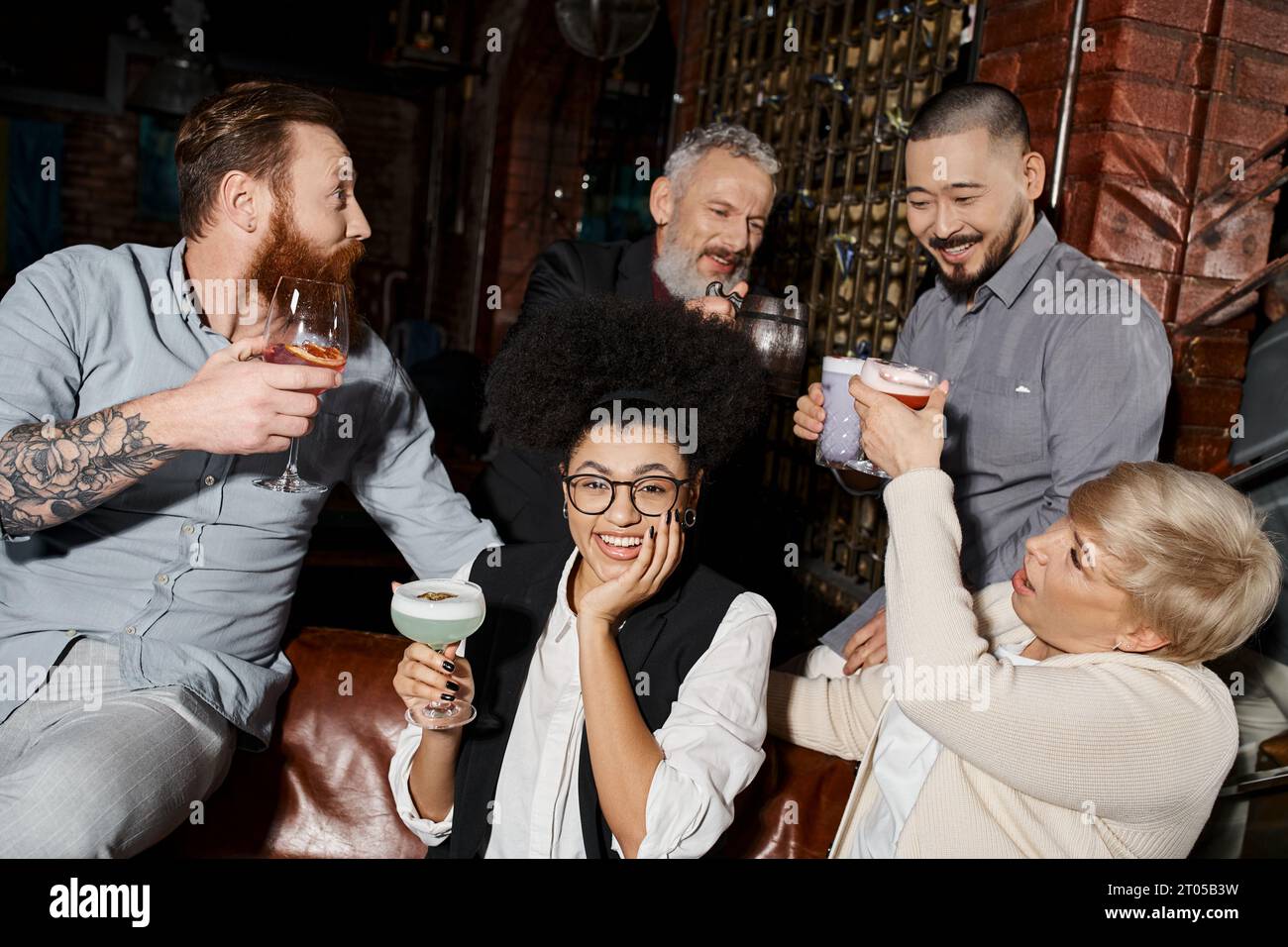 joyful african woman looking at camera near multiethnic colleagues ...
