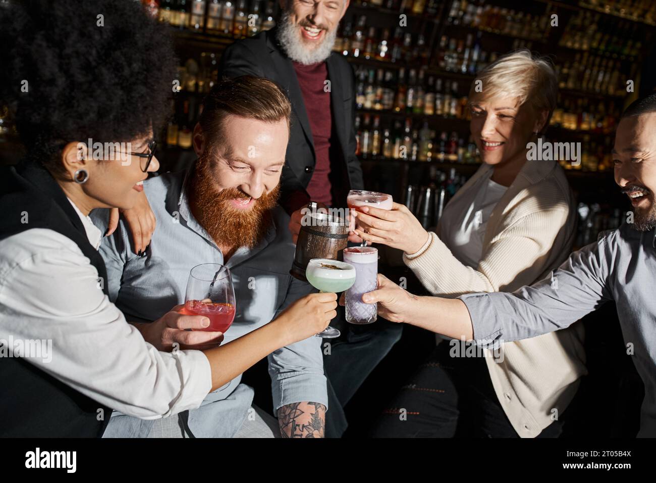 diverse team of cheerful multicultural friends clinking glasses while ...