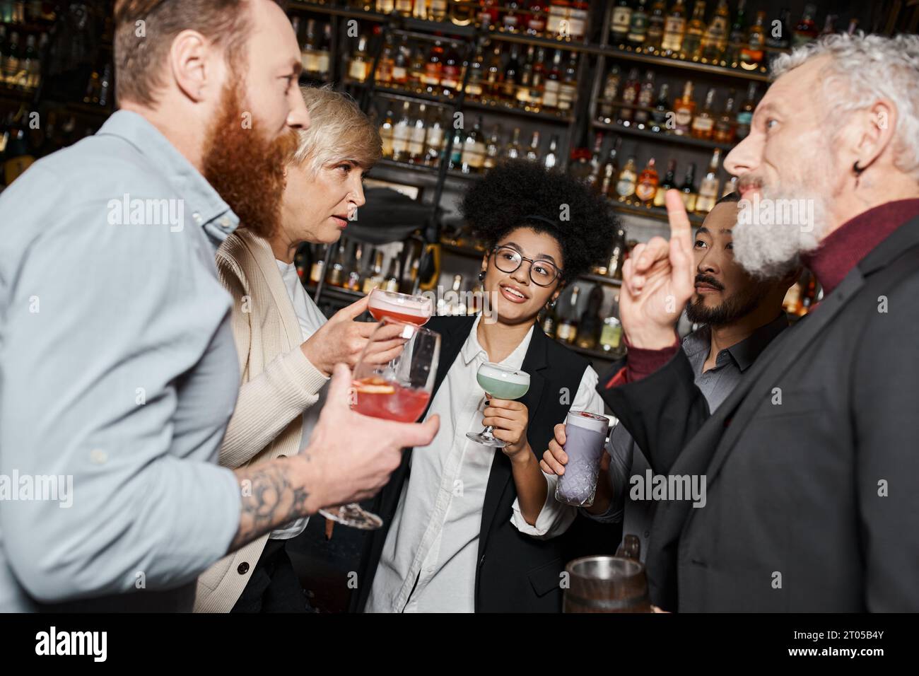 bearded man showing idea sign and talking to multiethnic colleagues ...