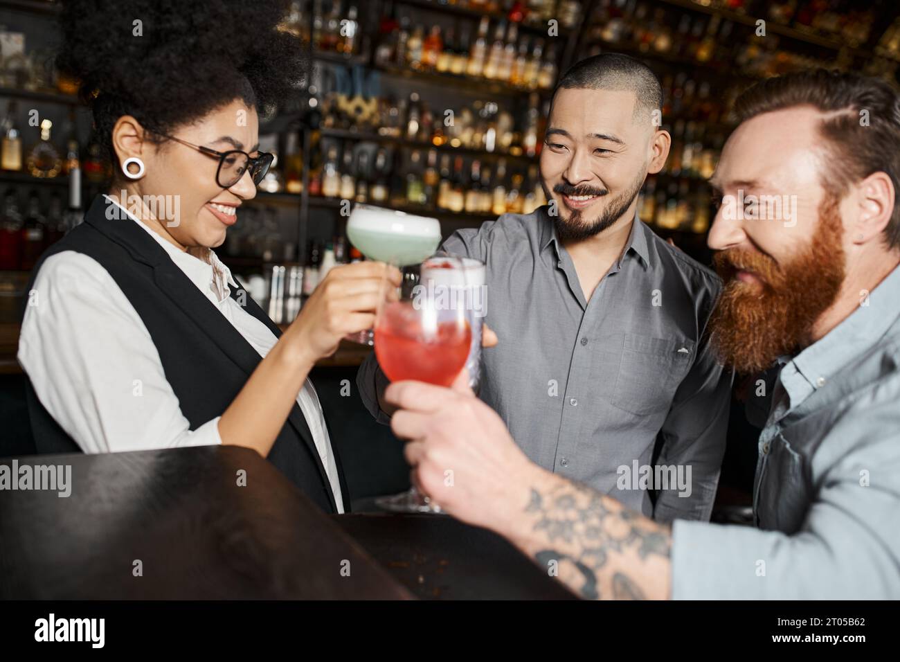 cheerful african american woman clinking glasses with multiethnic ...