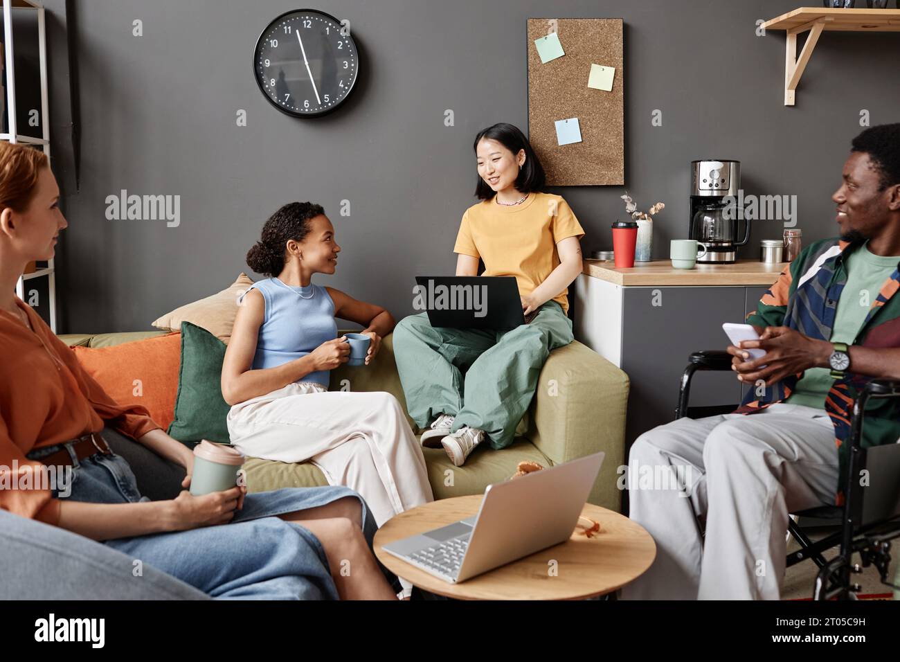 Diverse group of young professionals meeting in office lounge and ...