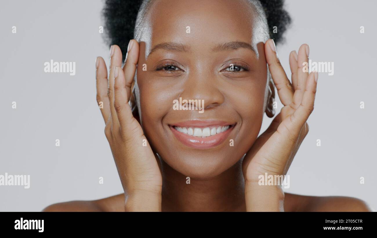 Face touch, skincare and happy black woman in studio isolated on a gray ...