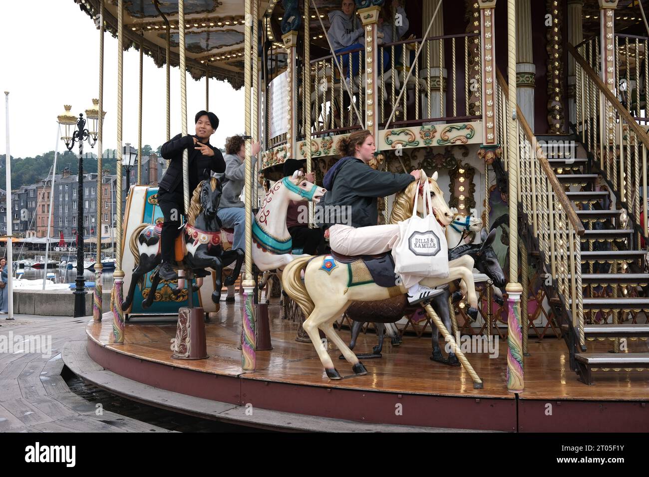Teenagers riding on the vintage Carousel at Avant Port, Honfleur ...