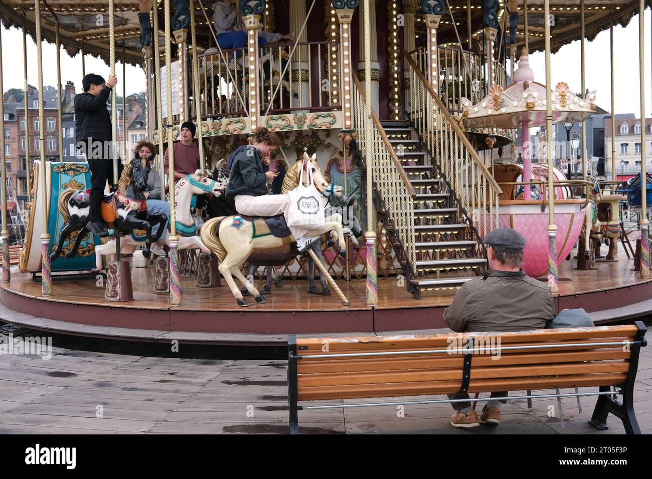 Teenagers riding on the vintage Carousel at Avant Port, Honfleur ...