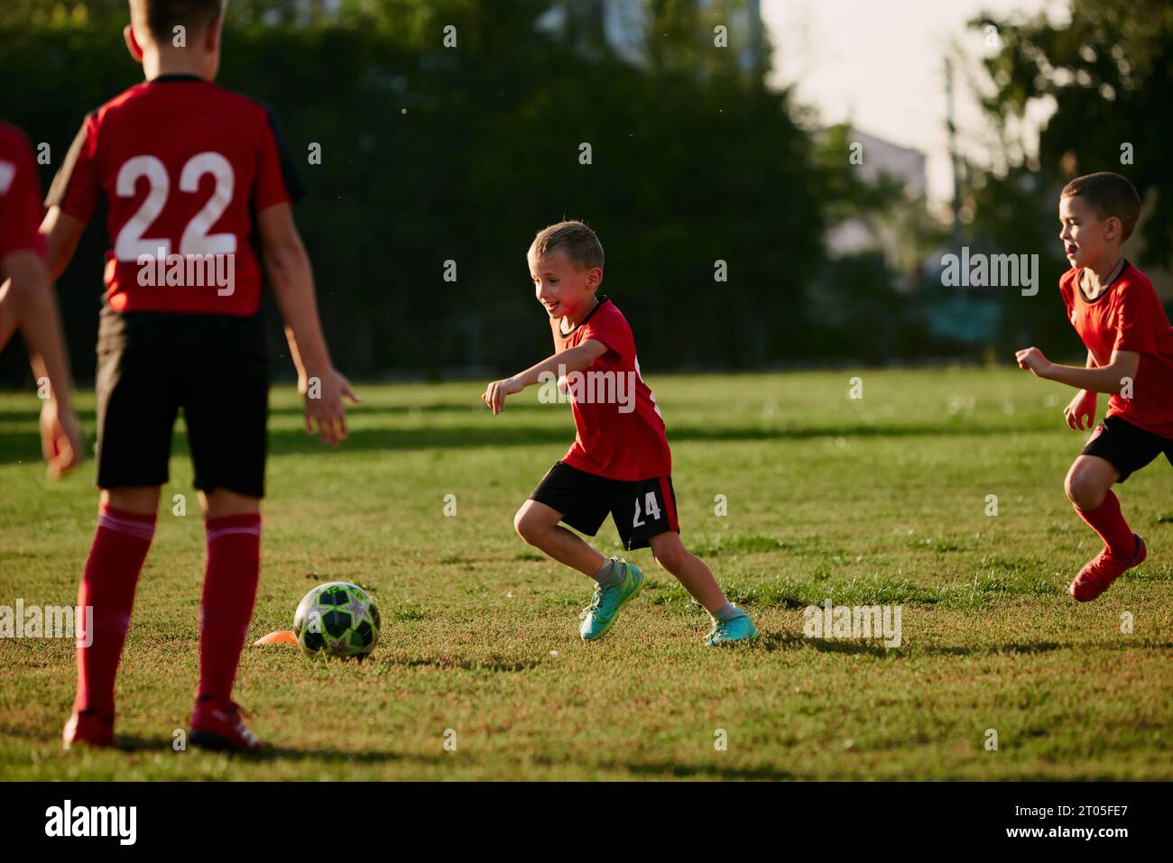 Full length photo of kids, football players in sport uniform playing in ...
