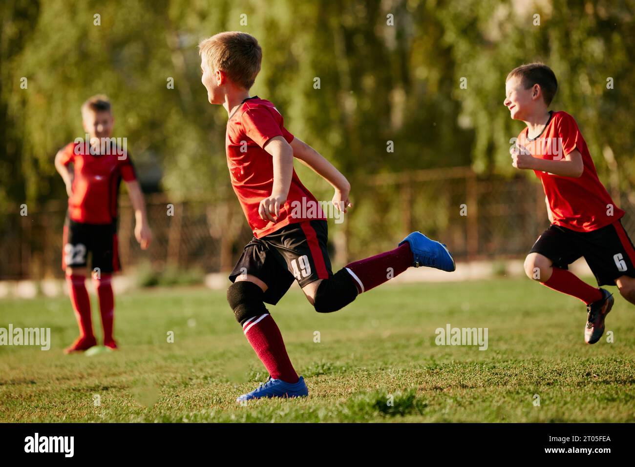 Full length side view portrait of kids, football players in sport ...