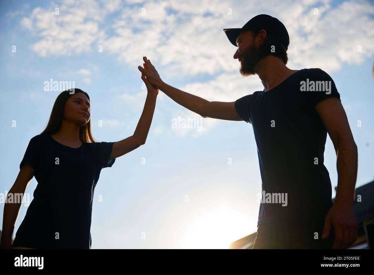 Man and woman, volunteers giving high five. Well-coordinated ...