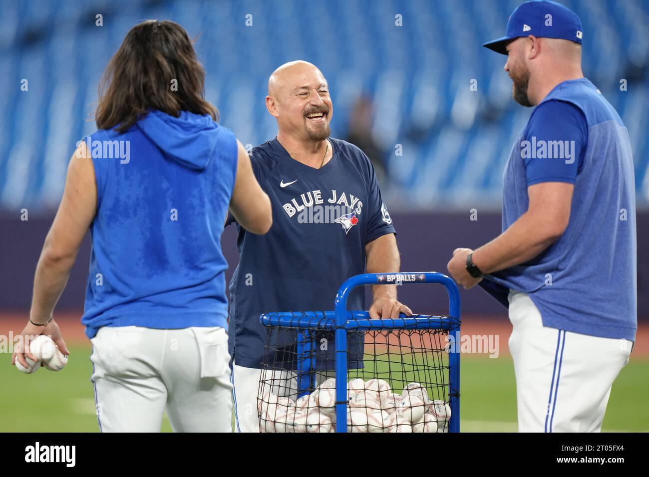 Toronto Blue Jays bullpen catcher Alex Andreopoulos shares a joke with Manager John Schneider ...