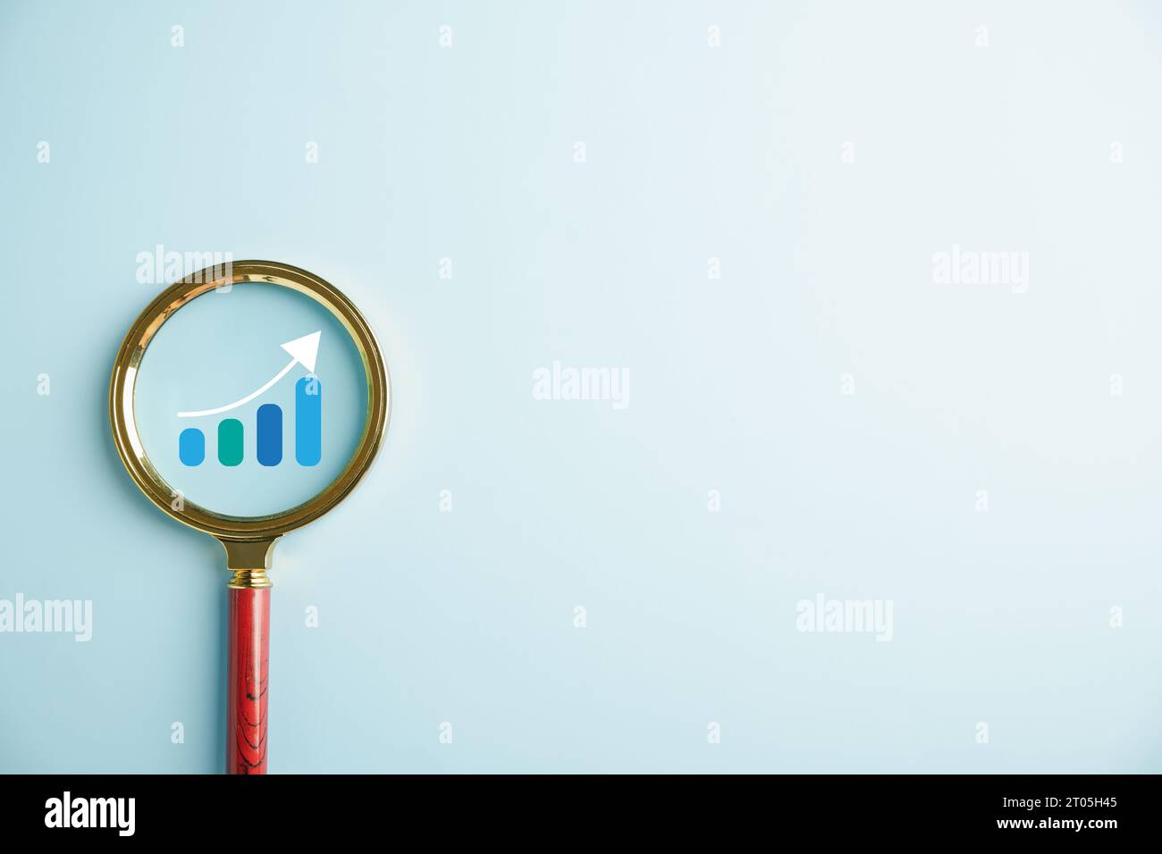 Trader hand holding magnifier glass with bar graph Stock Photo - Alamy