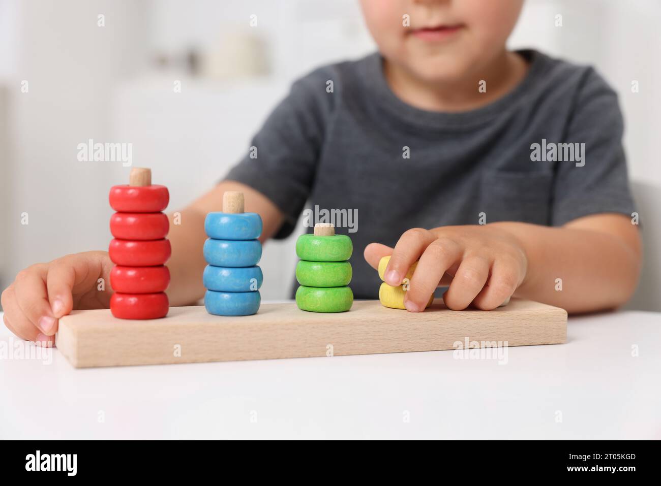 Motor skills development. Little boy playing with stacking and counting ...