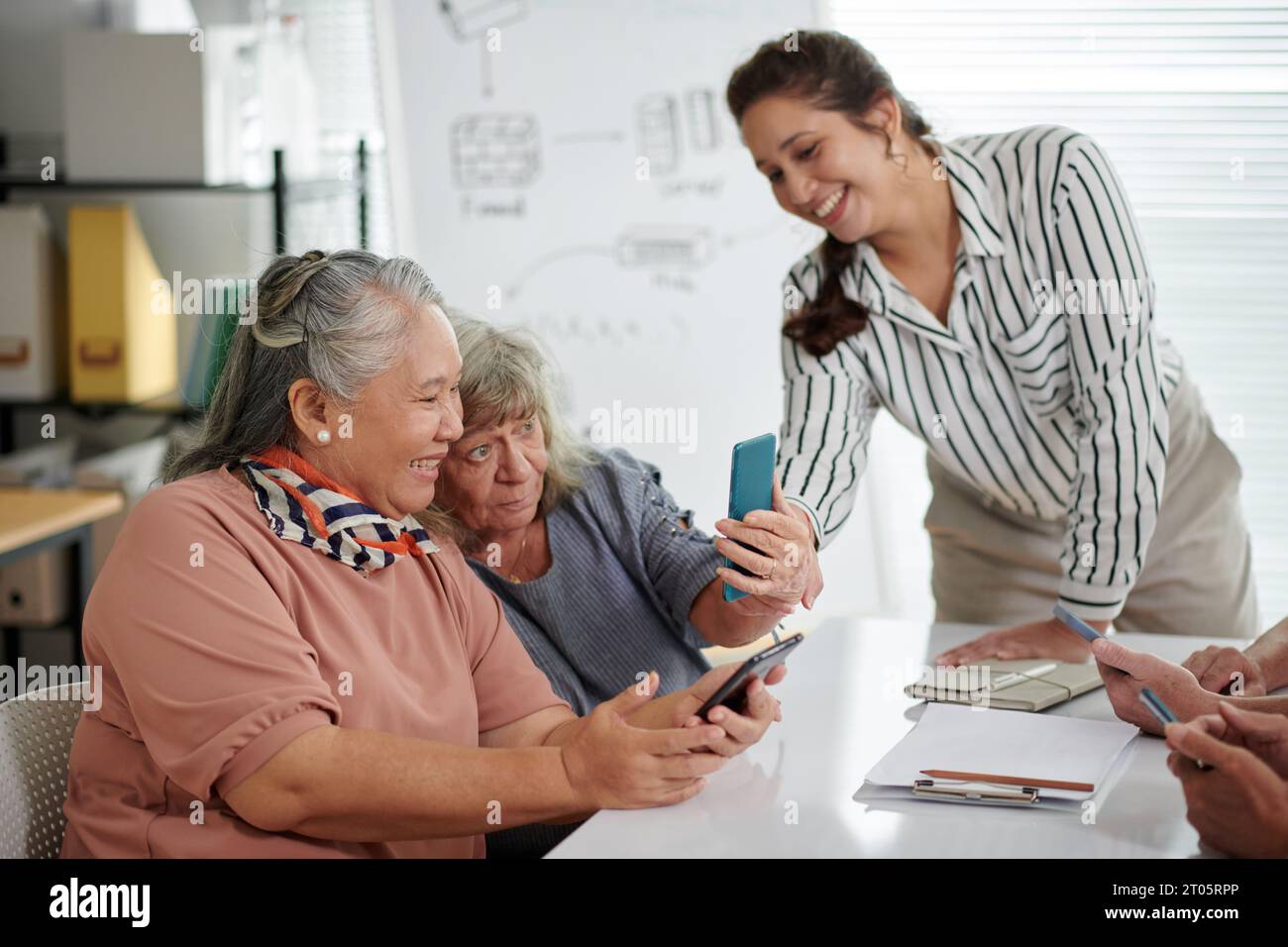 Senior women learning how to take seflie in class for older people ...