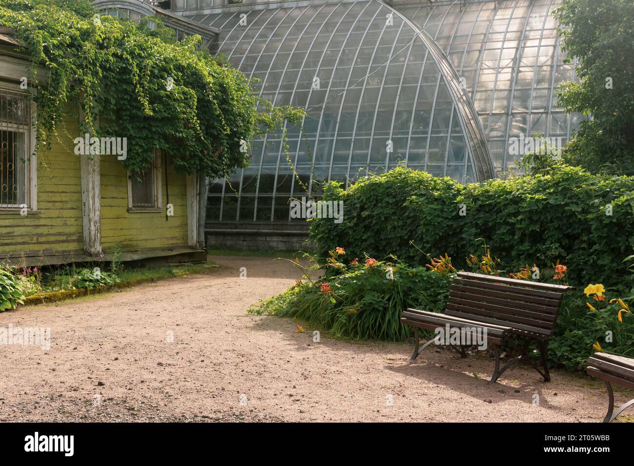 corner of an old botanical garden with a huge vintage greenhouse in the ...