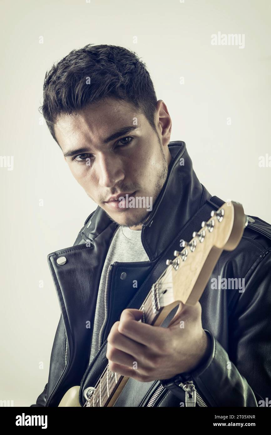 A man in a leather jacket holding a guitar. Photo of a musician rocking ...